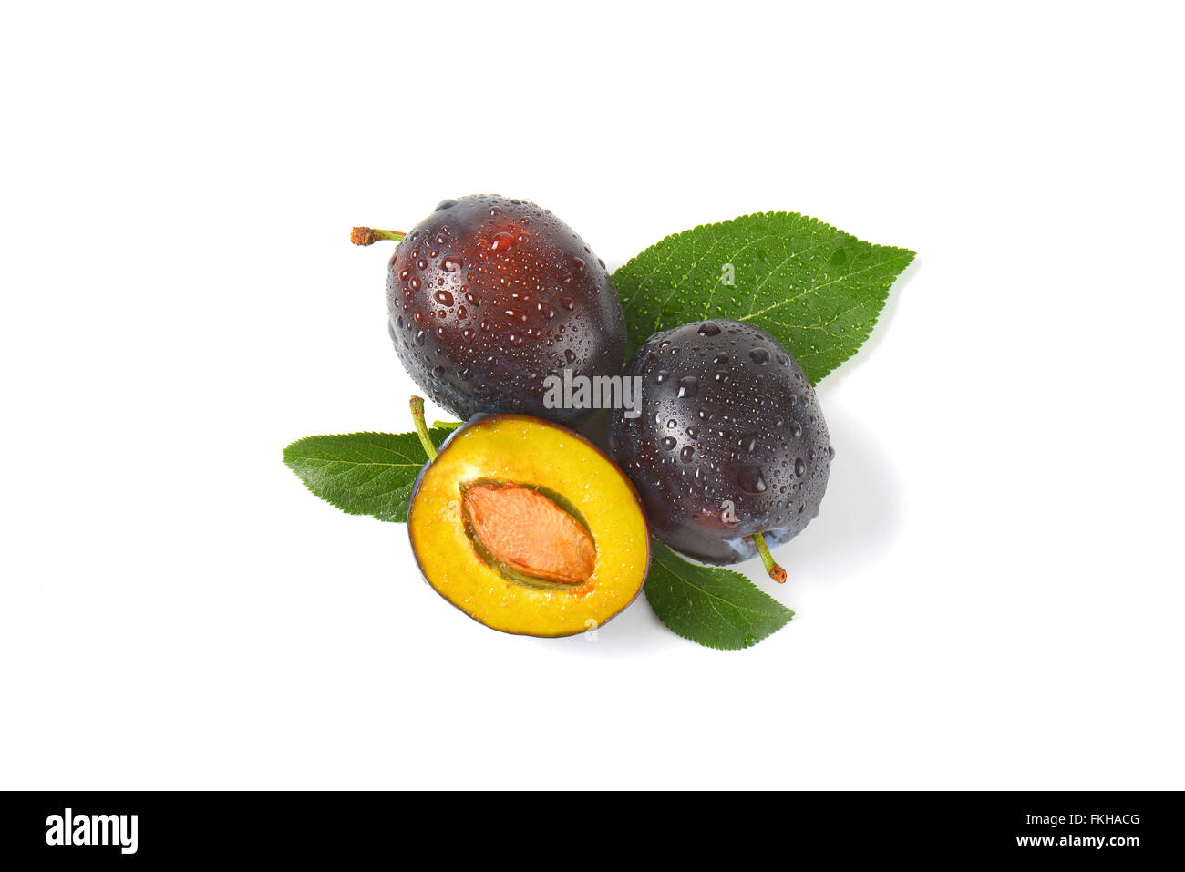 two and half washed plums on white background Stock Photo - Alamy