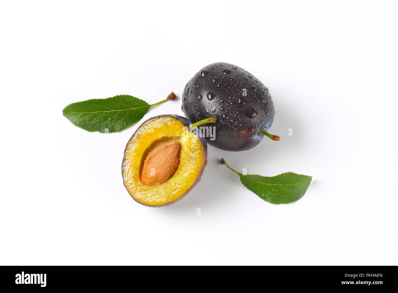 one and half washed plums on white background Stock Photo - Alamy