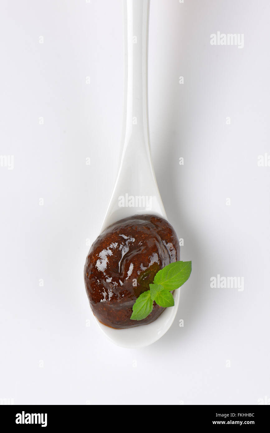 white spoon of plum jam on white background Stock Photo - Alamy