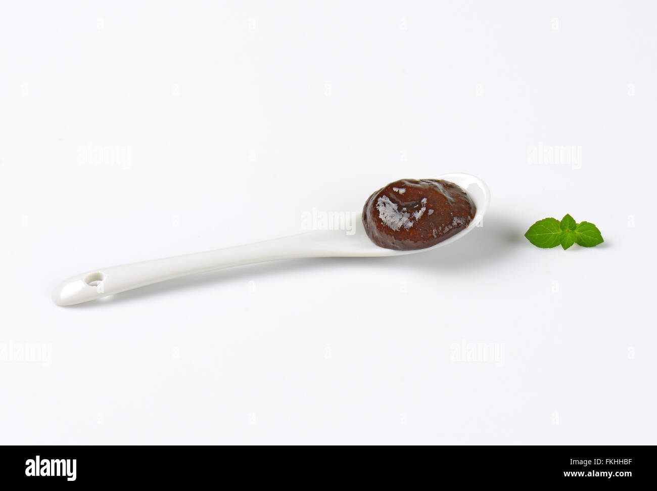 white spoon of plum jam on white background Stock Photo - Alamy