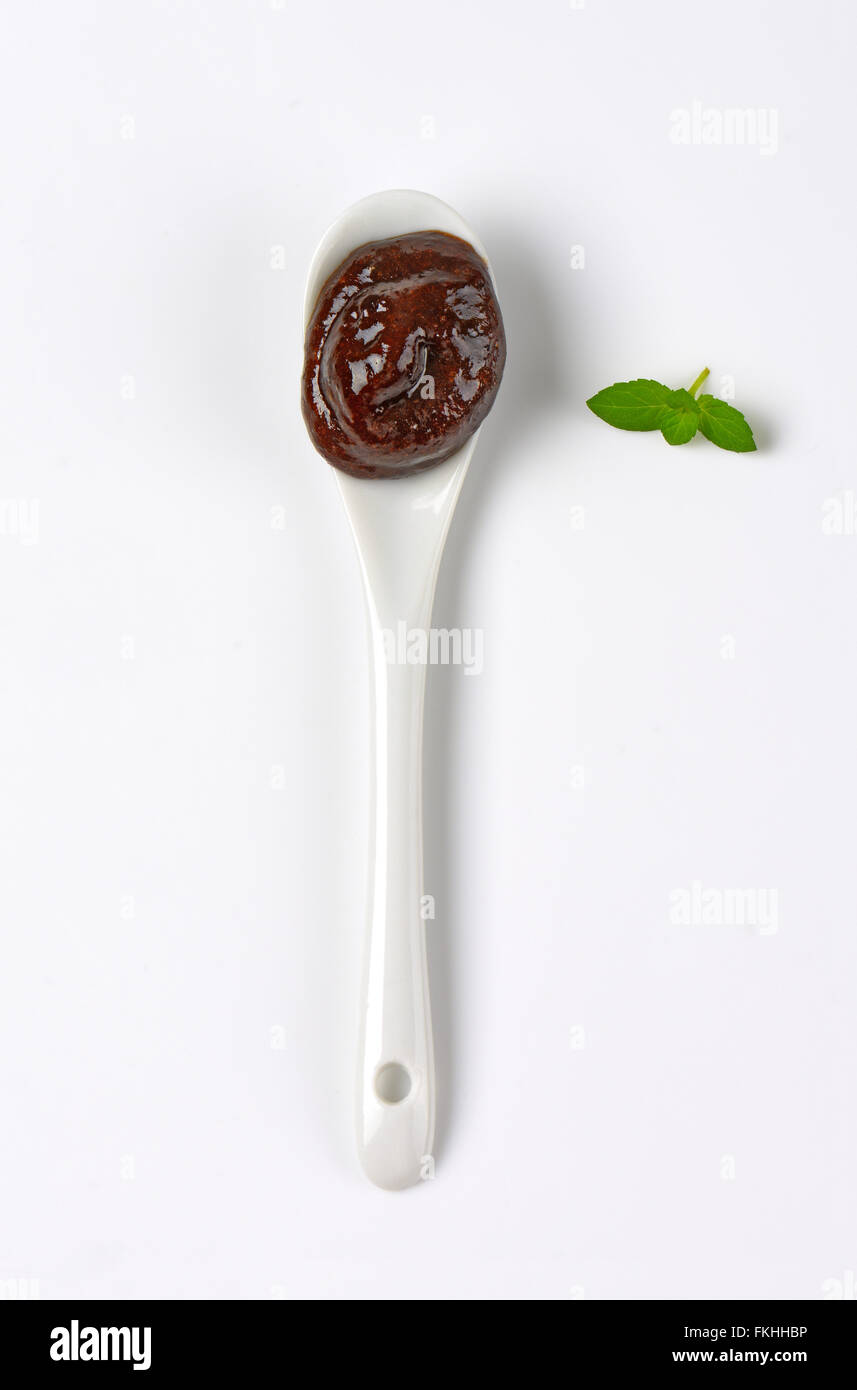 white spoon of plum jam on white background Stock Photo - Alamy
