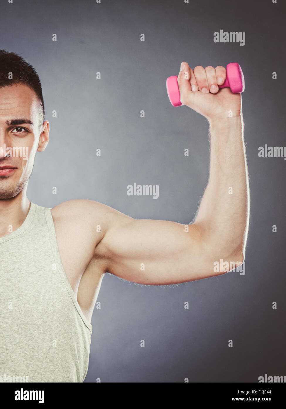 Funny sporty fit man lifting light dumbbell weight. Young muscular ...