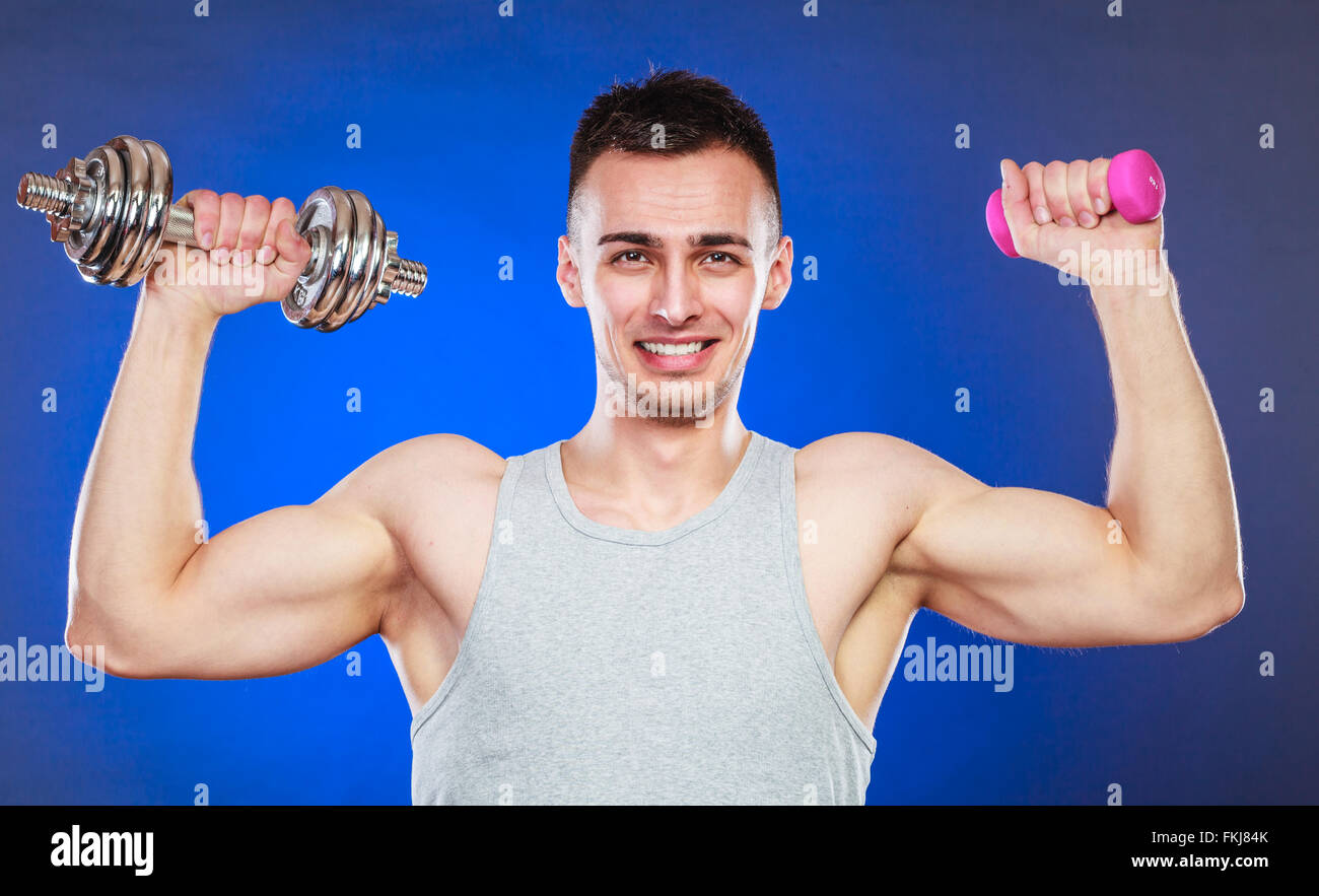 Sporty fit man lifting light and heavy dumbbells weights. Young ...