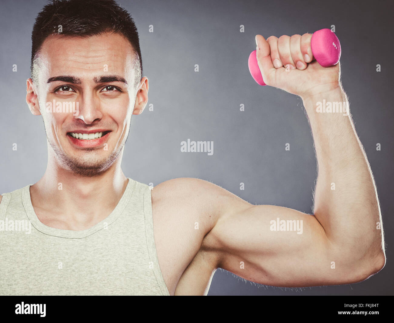 Funny sporty fit man lifting light dumbbell weight. Young muscular ...