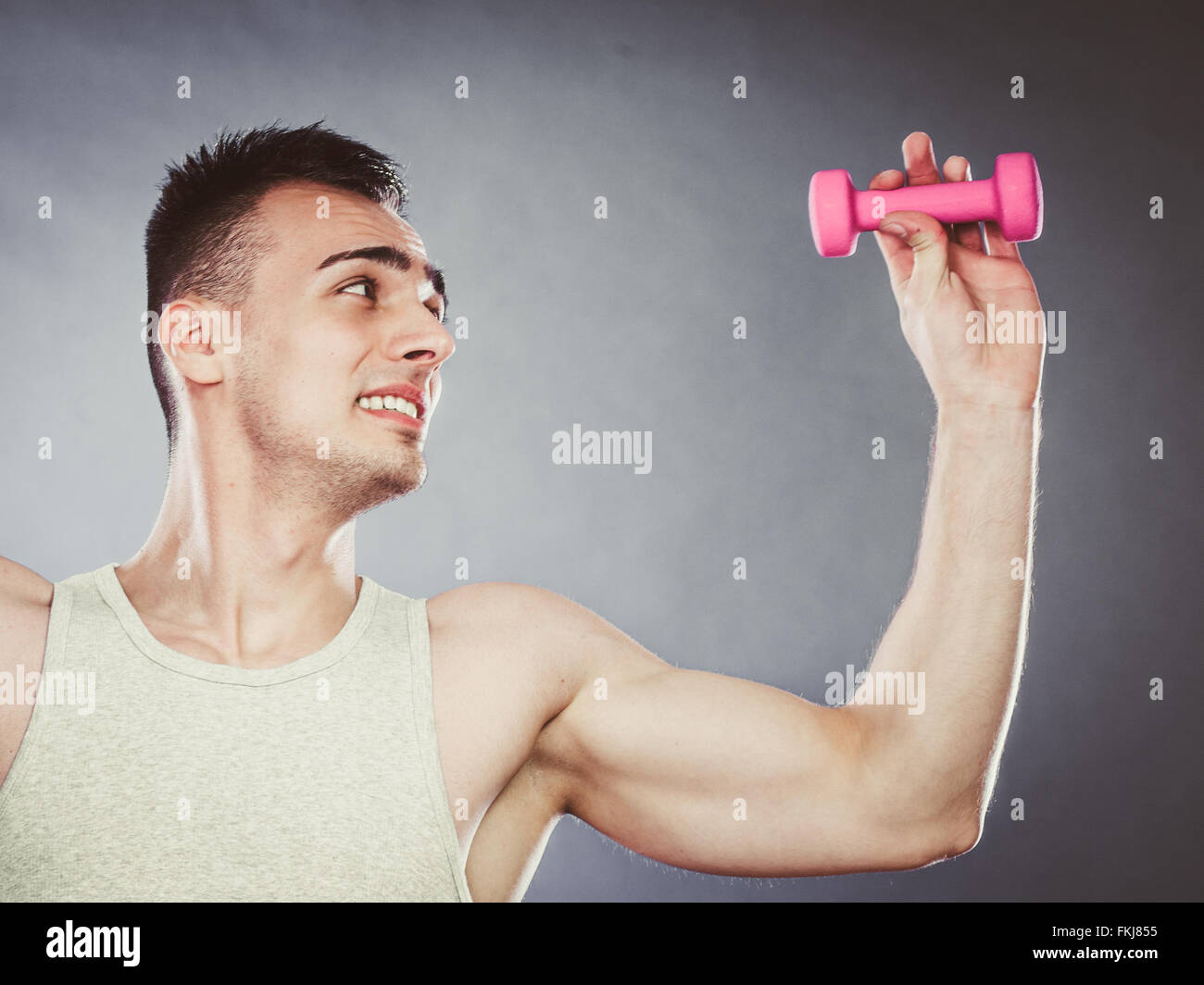 Funny sporty fit man lifting light dumbbell weight. Young muscular ...