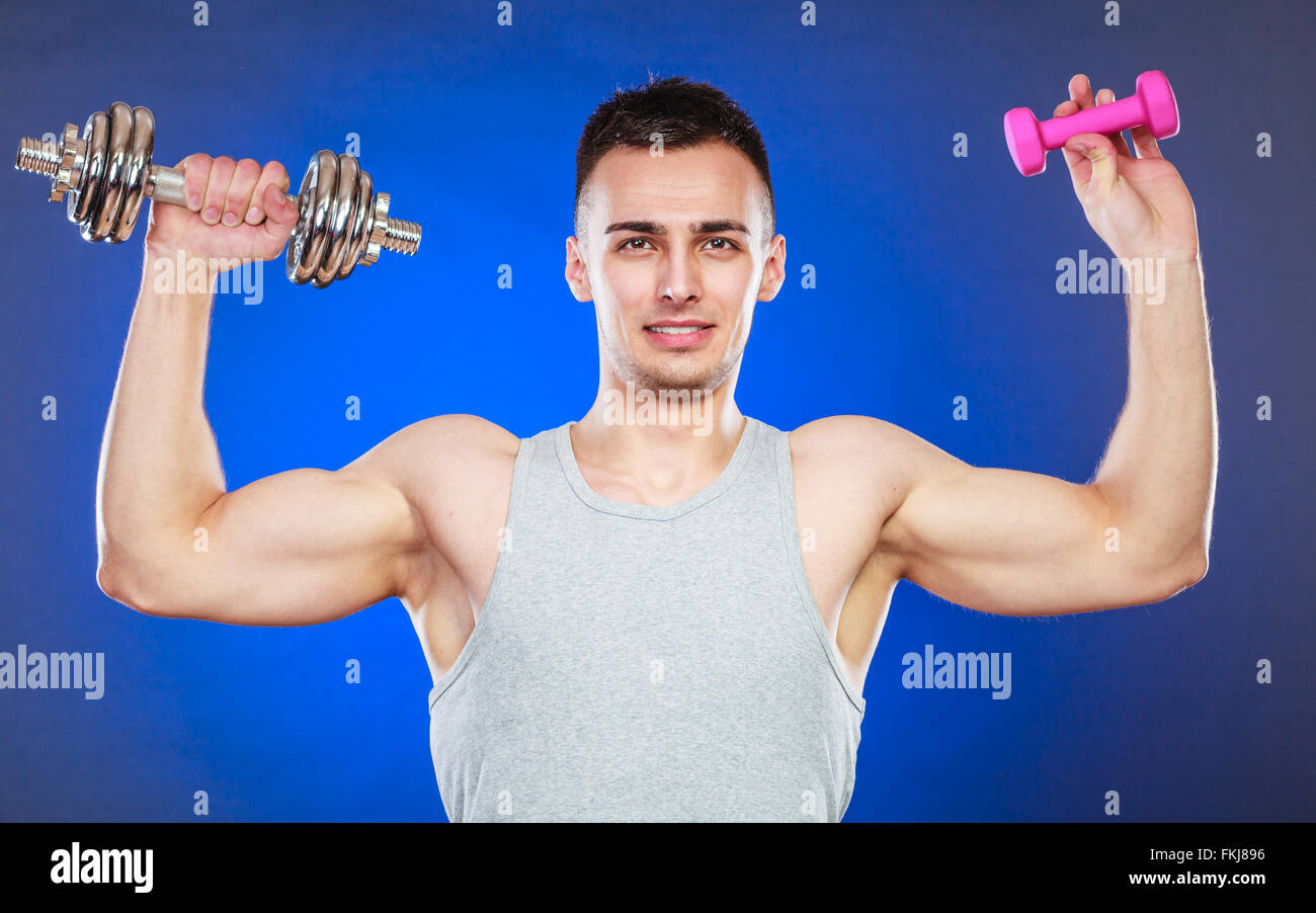 Sporty fit man lifting light and heavy dumbbells weights. Young ...