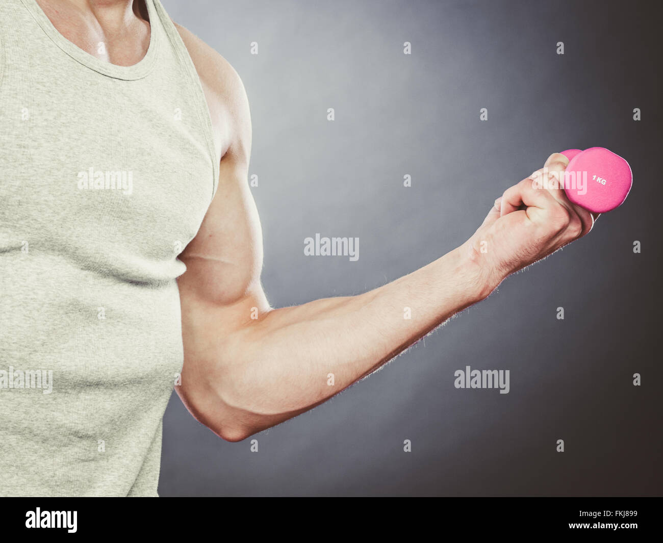 Funny sporty fit man lifting light dumbbell weight. Closeup of muscular ...