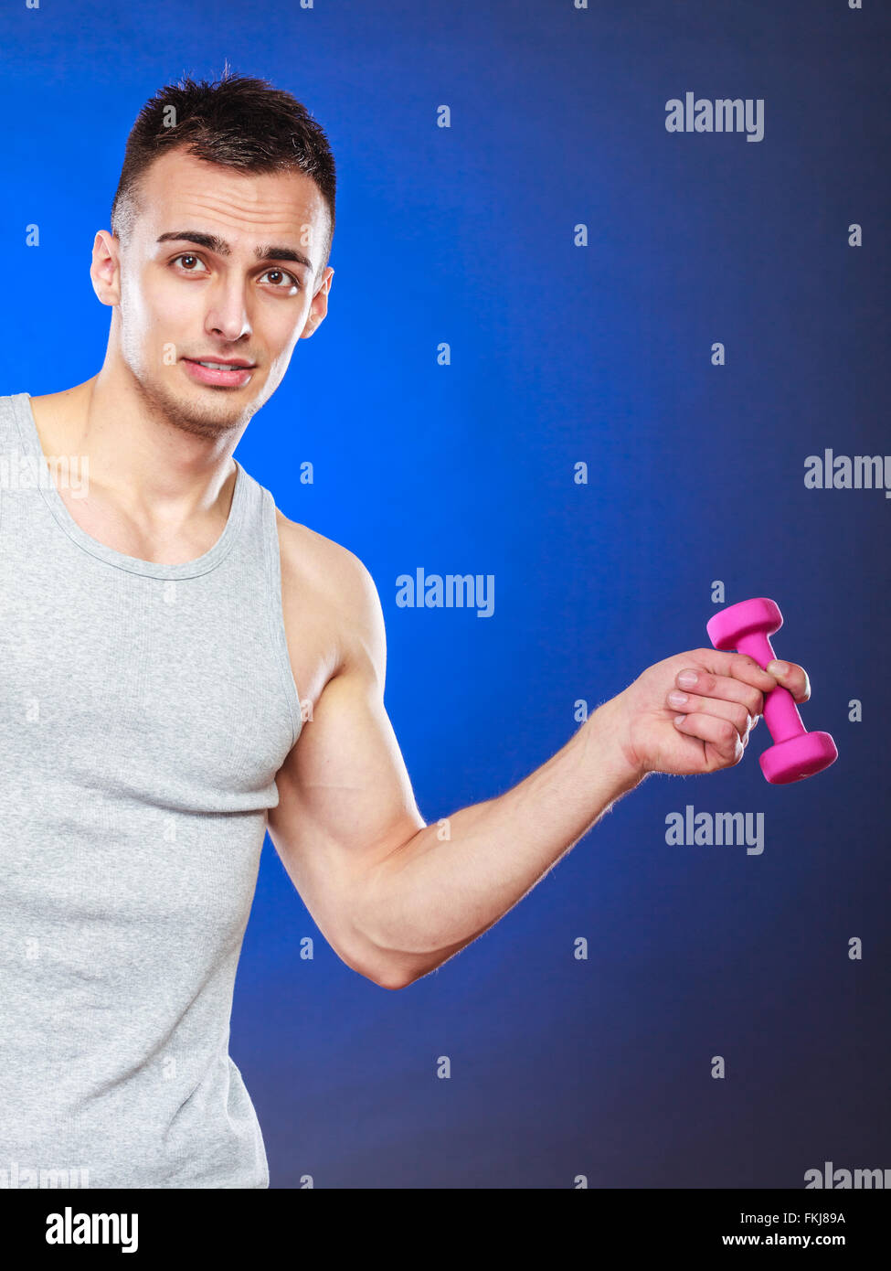 Funny sporty fit man lifting light dumbbell weight. Young muscular ...