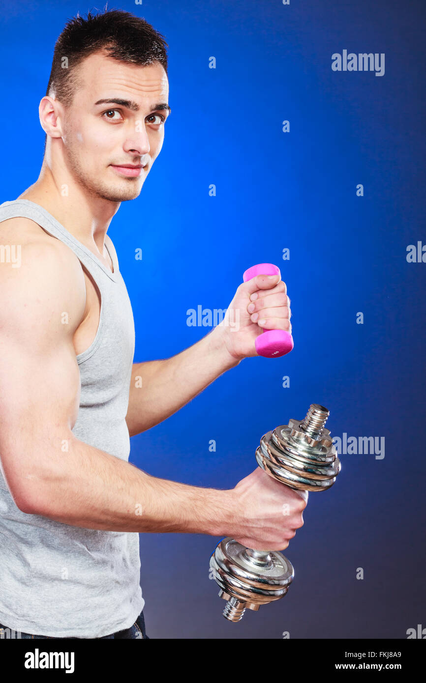 Sporty fit man lifting light and heavy dumbbells weights. Young ...