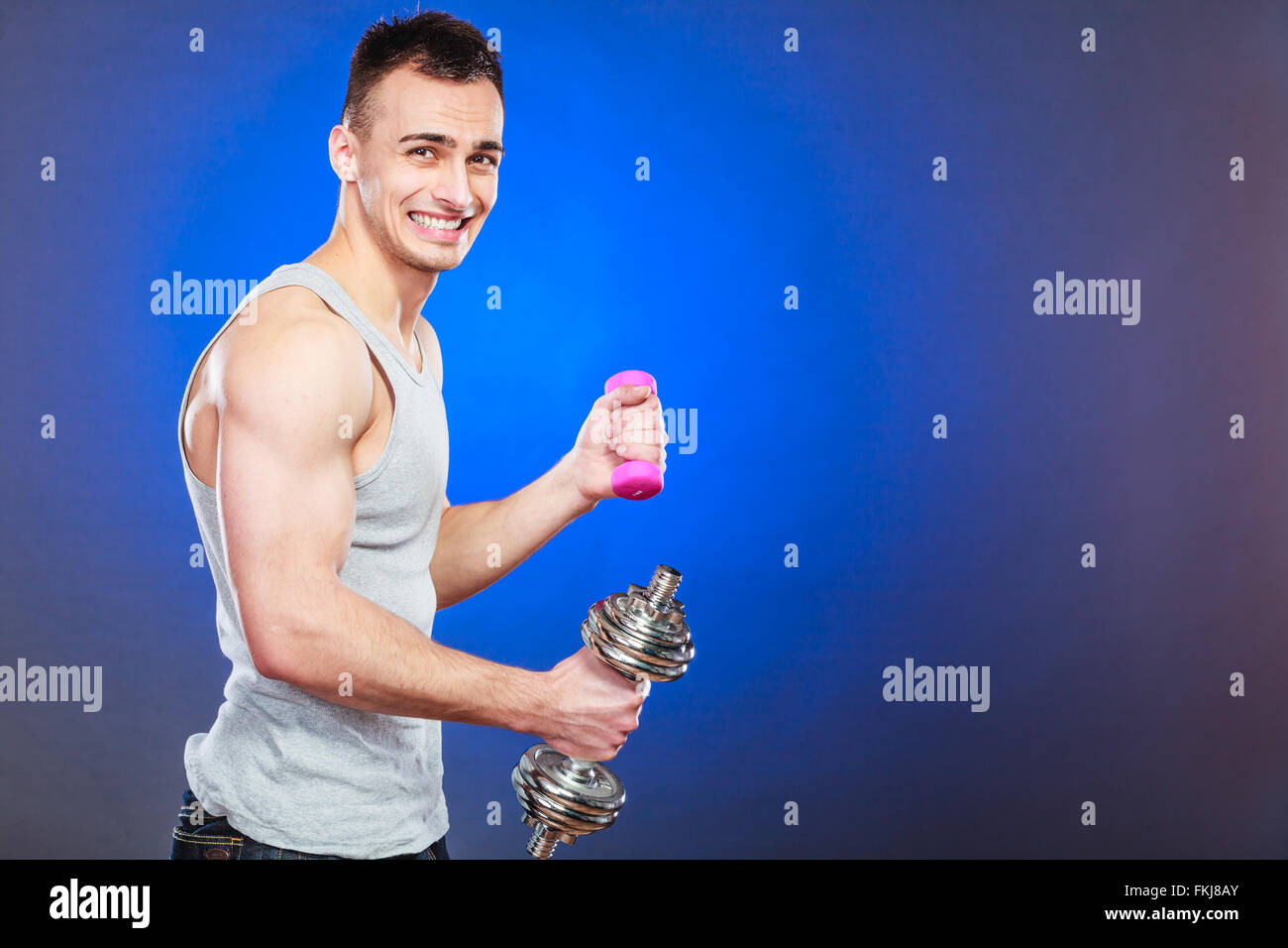 Sporty fit man lifting light and heavy dumbbells weights. Young ...