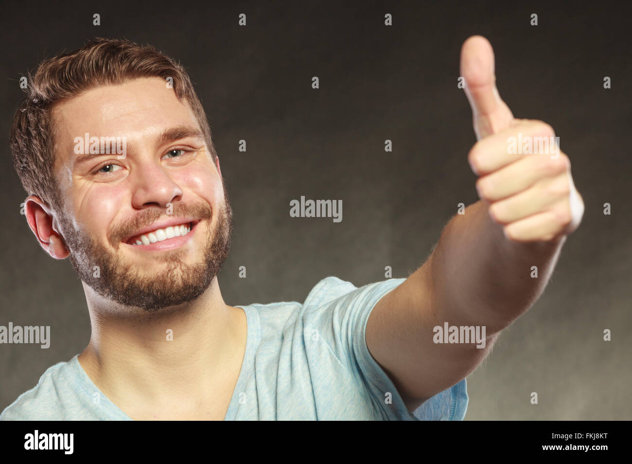 Portrait of happy smiling handsome man guy giving thumb up gesture in ...