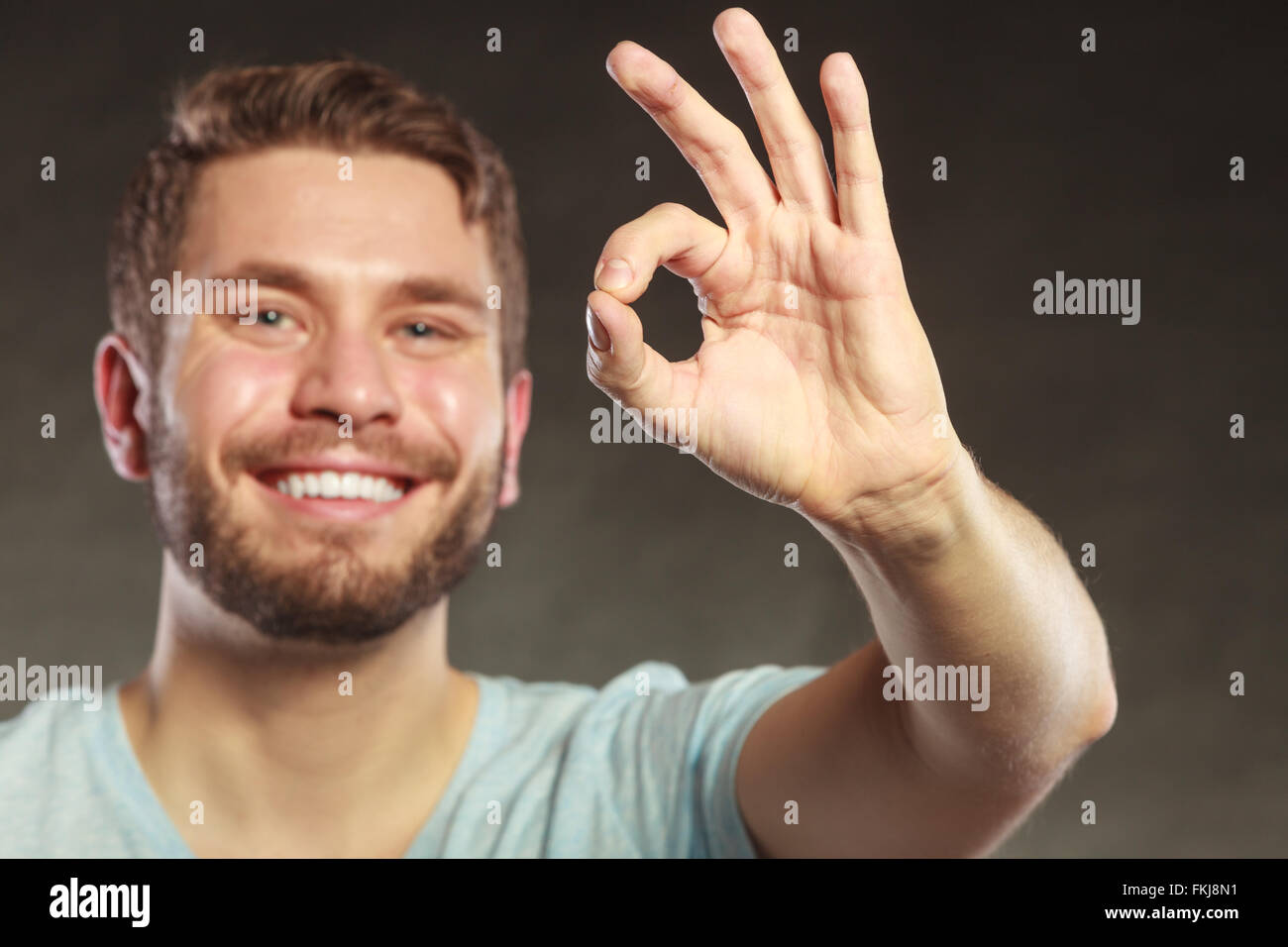Portrait of happy smiling handsome man guy giving ok okay sign gesture ...