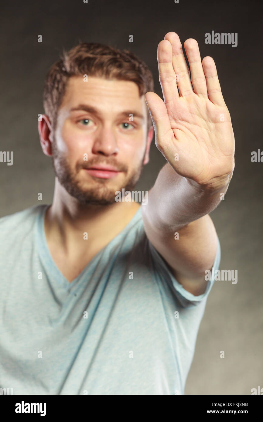 Portrait of handsome man guy giving stop sign gesture in studio on ...