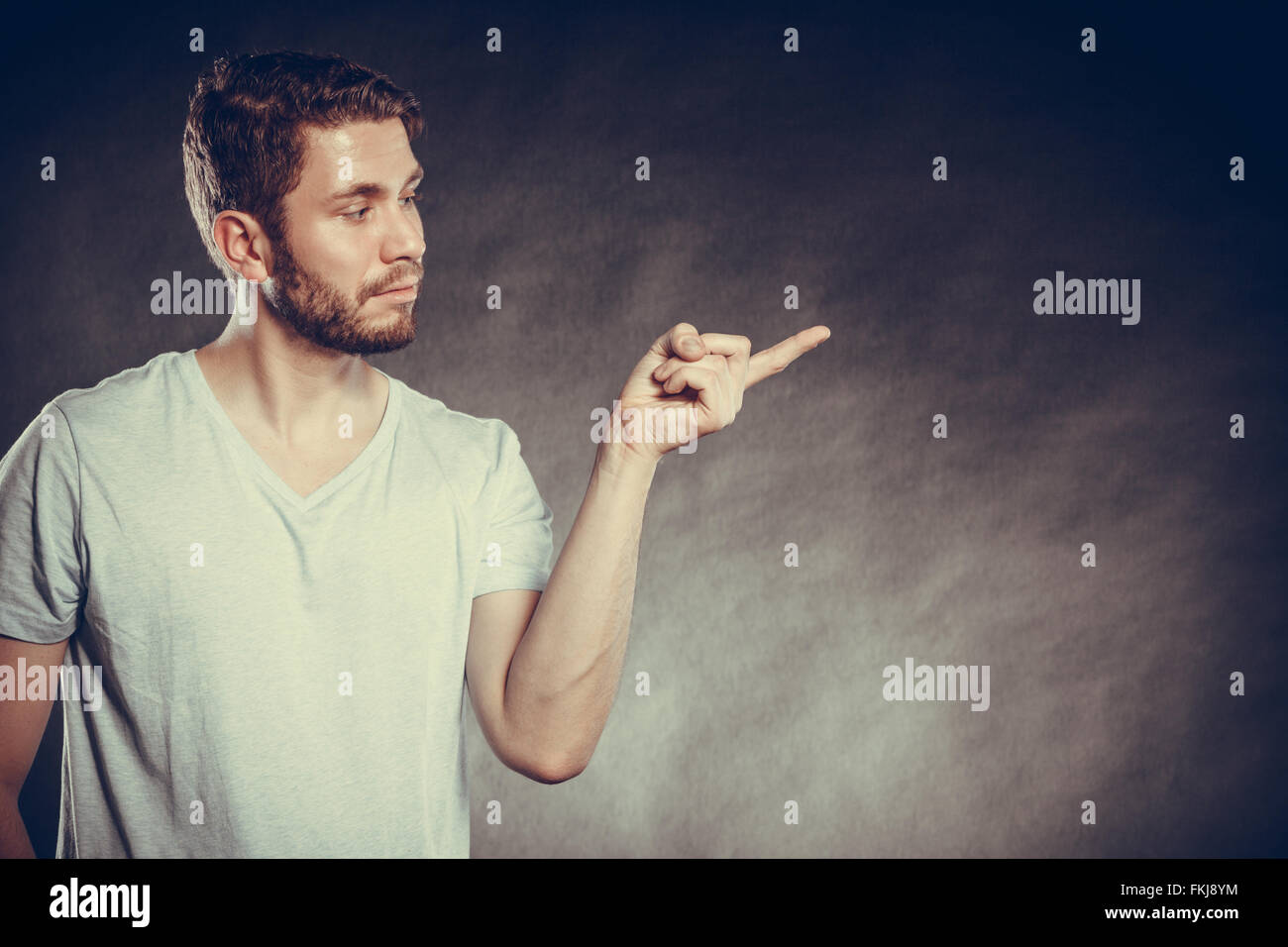 Portrait of handsome man pointing at empty blank copy space. Young guy ...