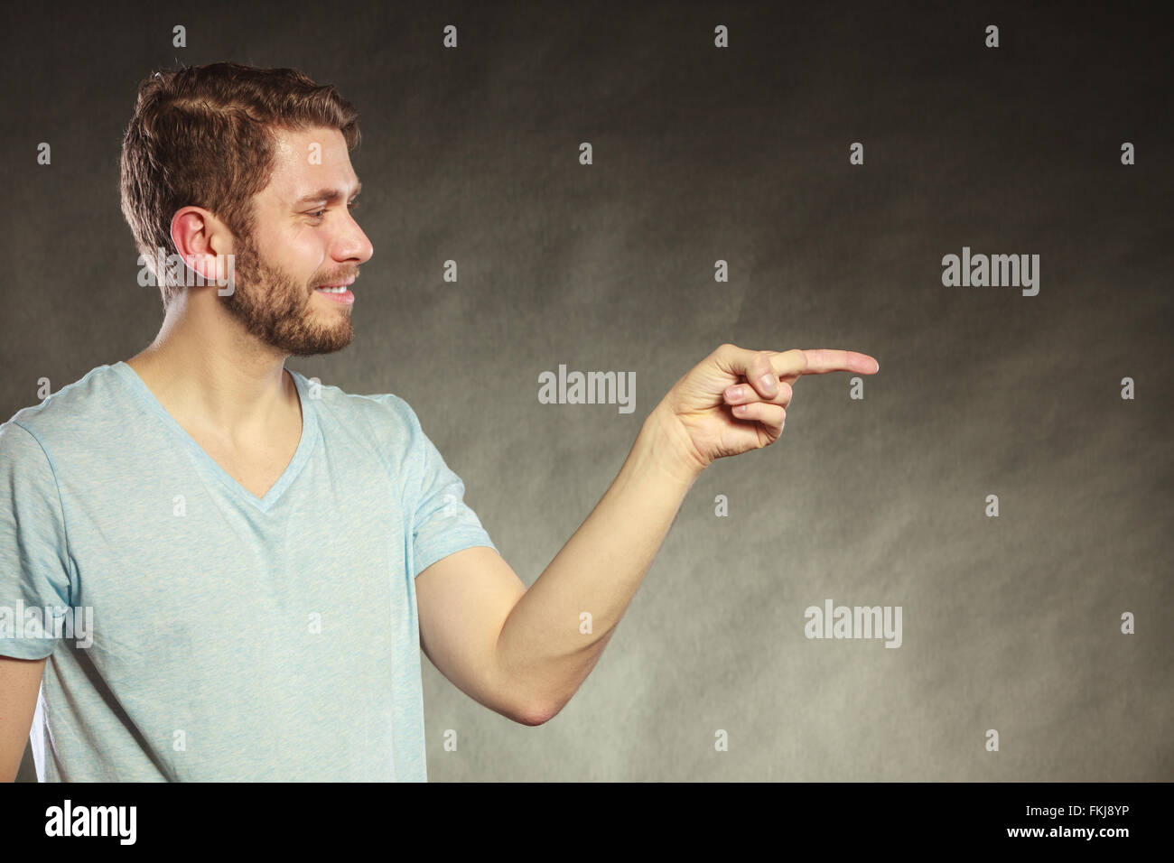 Portrait of handsome man pointing at empty blank copy space. Young guy ...