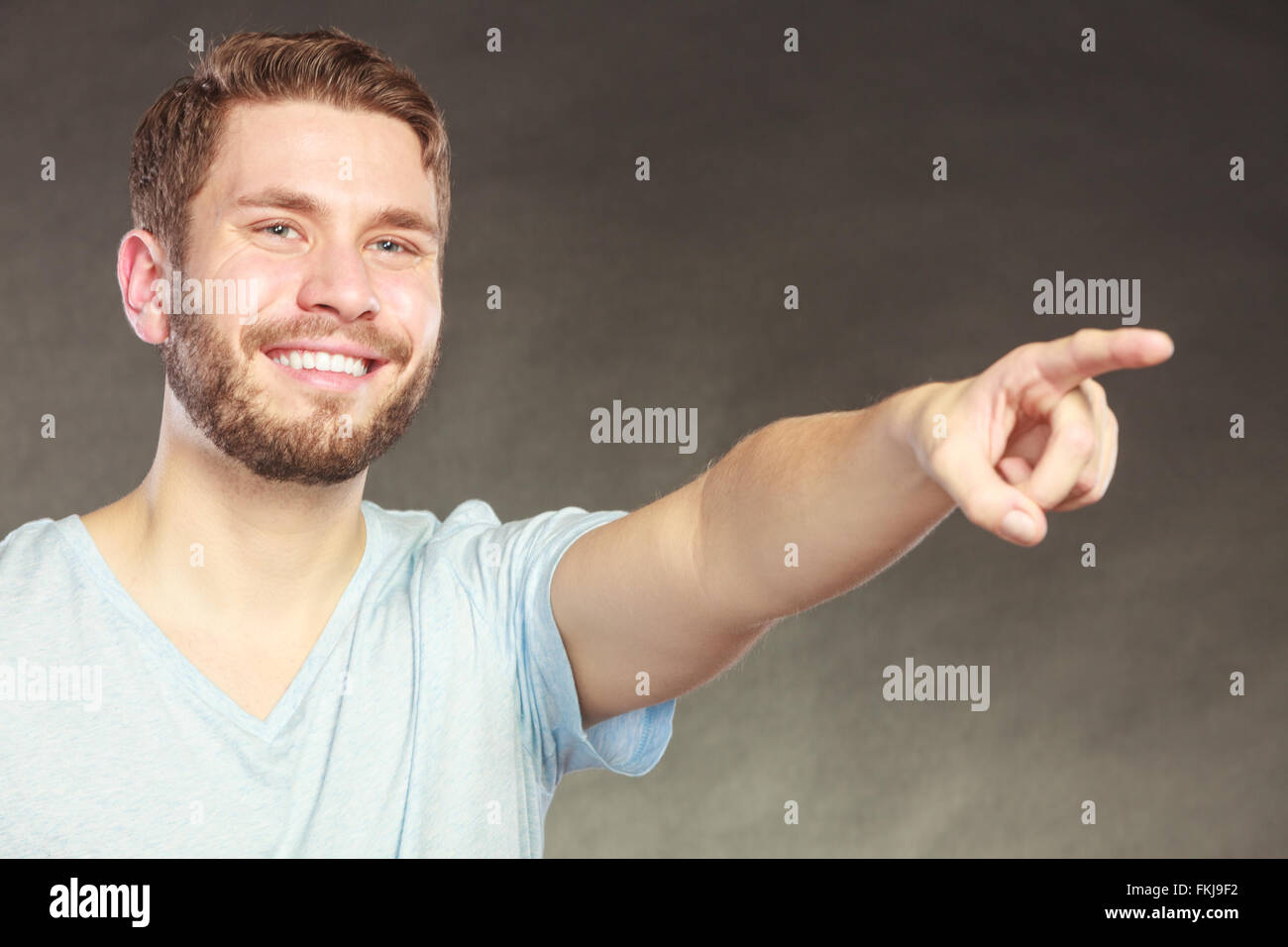 Portrait of handsome man pointing at empty blank copy space. Young guy ...