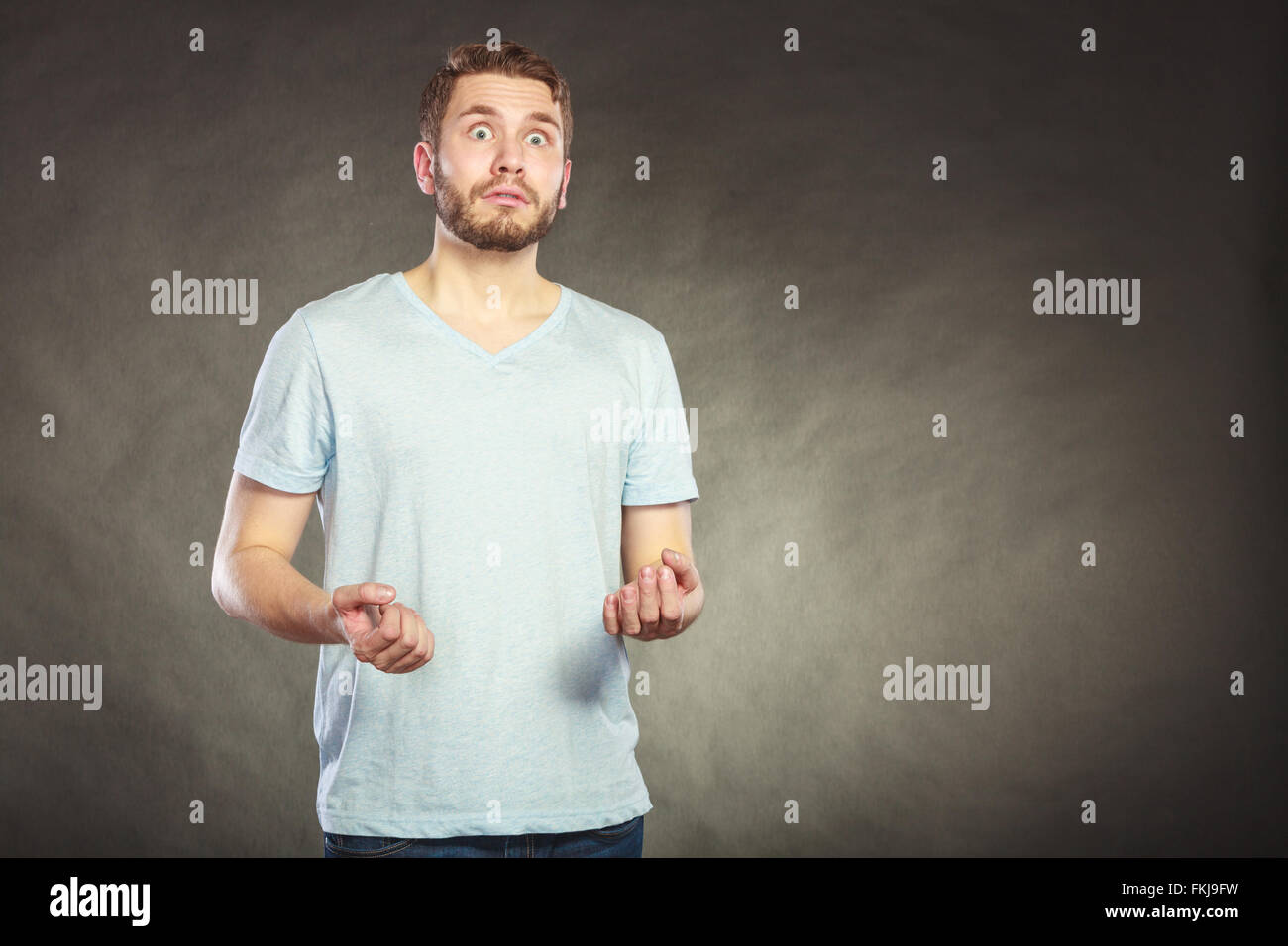 Portrait of scared afraid shocked handsome man in shirt. Young guy ...