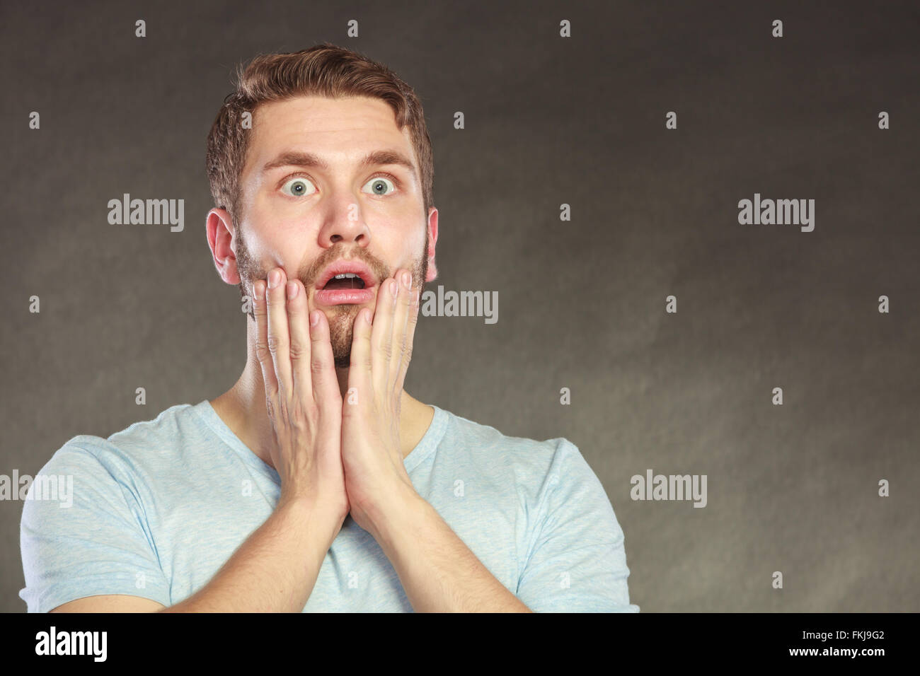 Portrait of scared afraid shocked handsome man in shirt. Young guy ...
