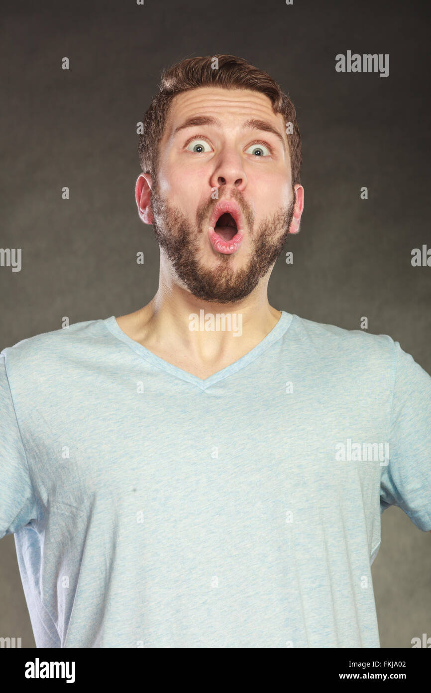 Portrait of shocked surprised amazed handsome man in shirt. Young guy ...