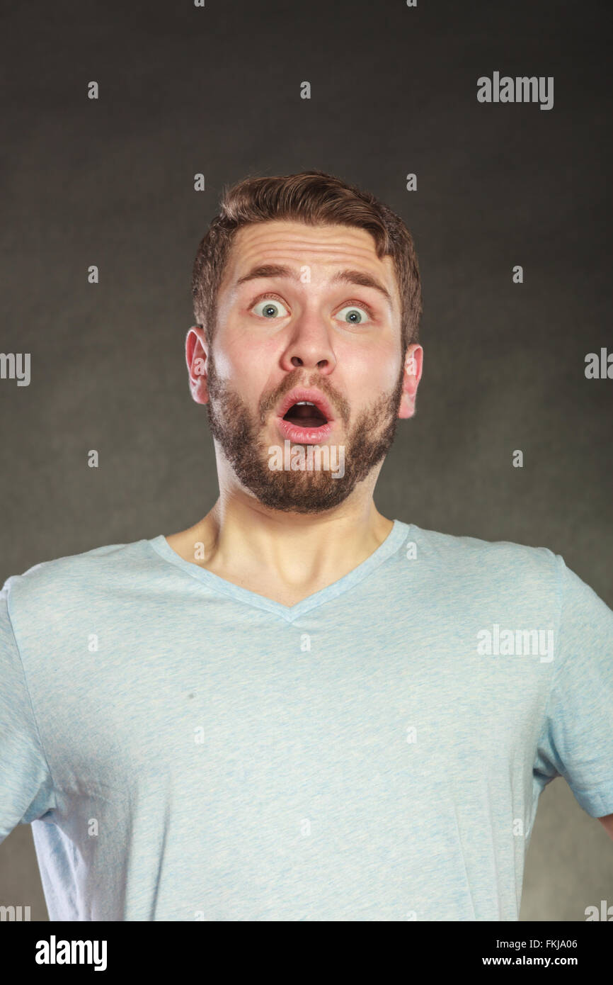 Portrait of shocked surprised amazed handsome man in shirt. Young guy ...