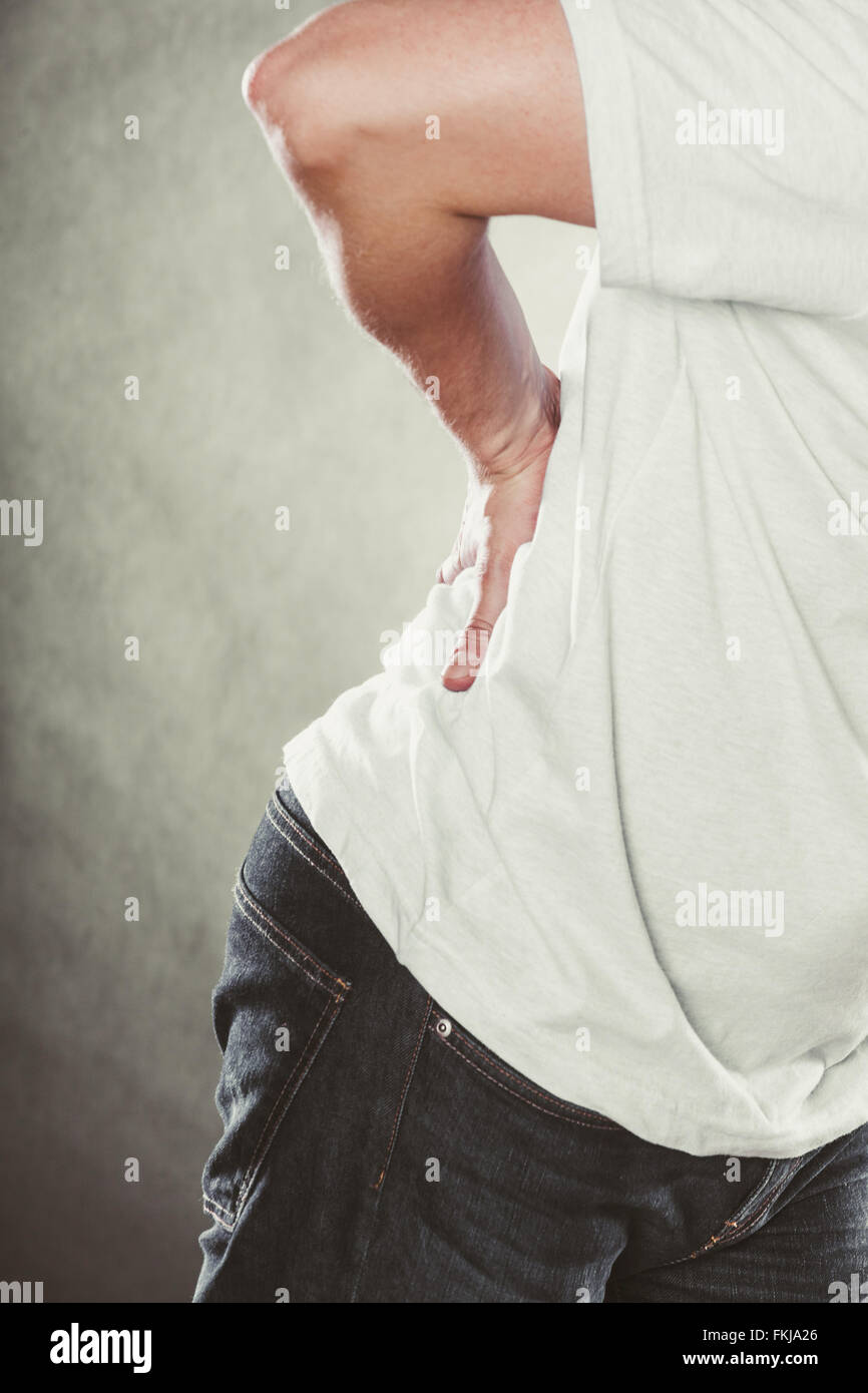 Man suffering from backache back pain. Guy in studio on black Stock ...
