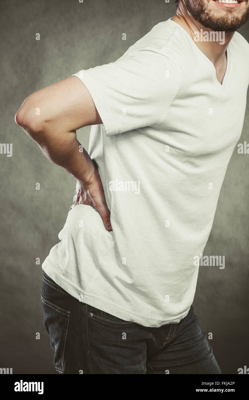 Man suffering from backache back pain. Guy in studio on black Stock ...