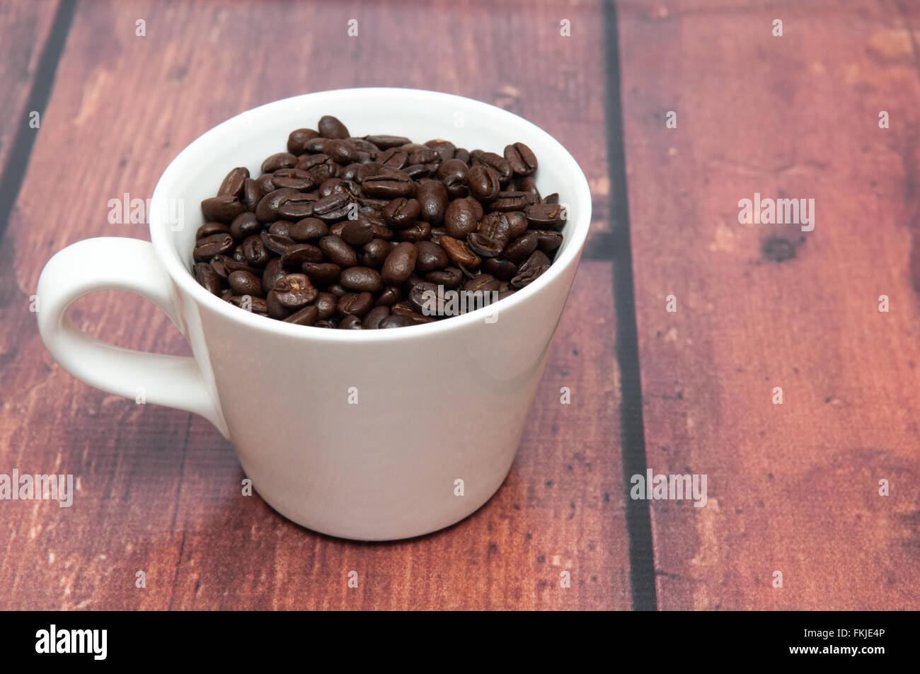 Strong flavored coffee beans in a plain white mug Stock Photo - Alamy