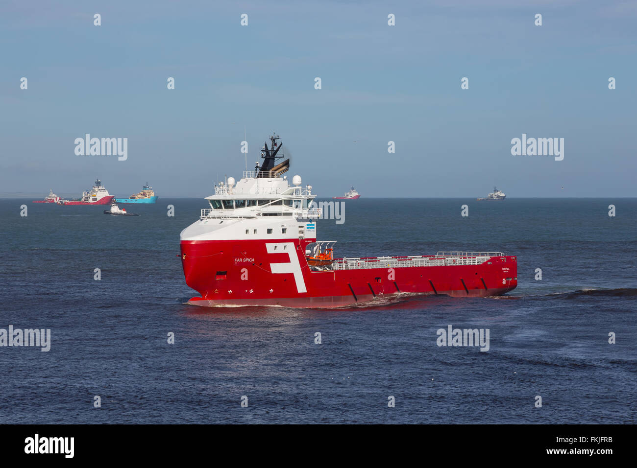 Red Oil rig supply vessel sailing in the North Sea enters the harbour ...