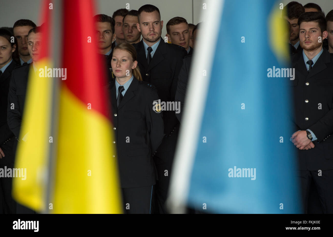 Young police officers stand behind a German and European Union flag ...
