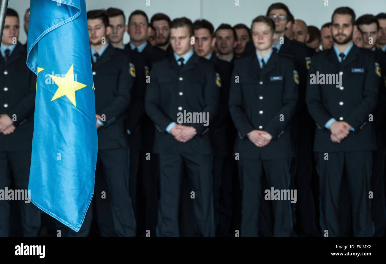 Young police officers stand behind a European Union flag during their ...
