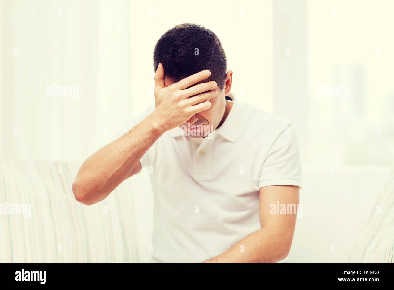 unhappy man suffering from head ache at home Stock Photo - Alamy