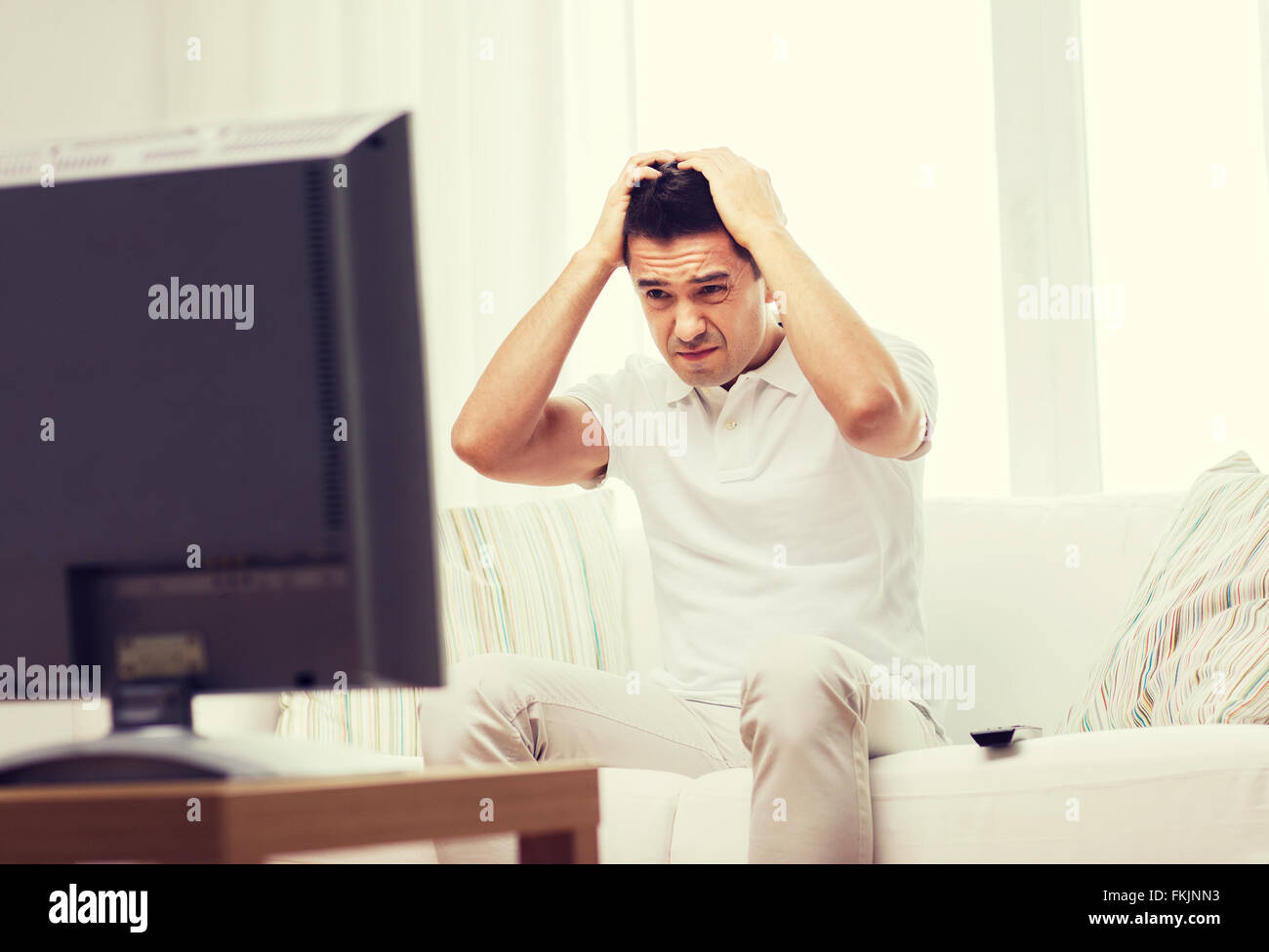 disappointed man watching tv at home Stock Photo - Alamy