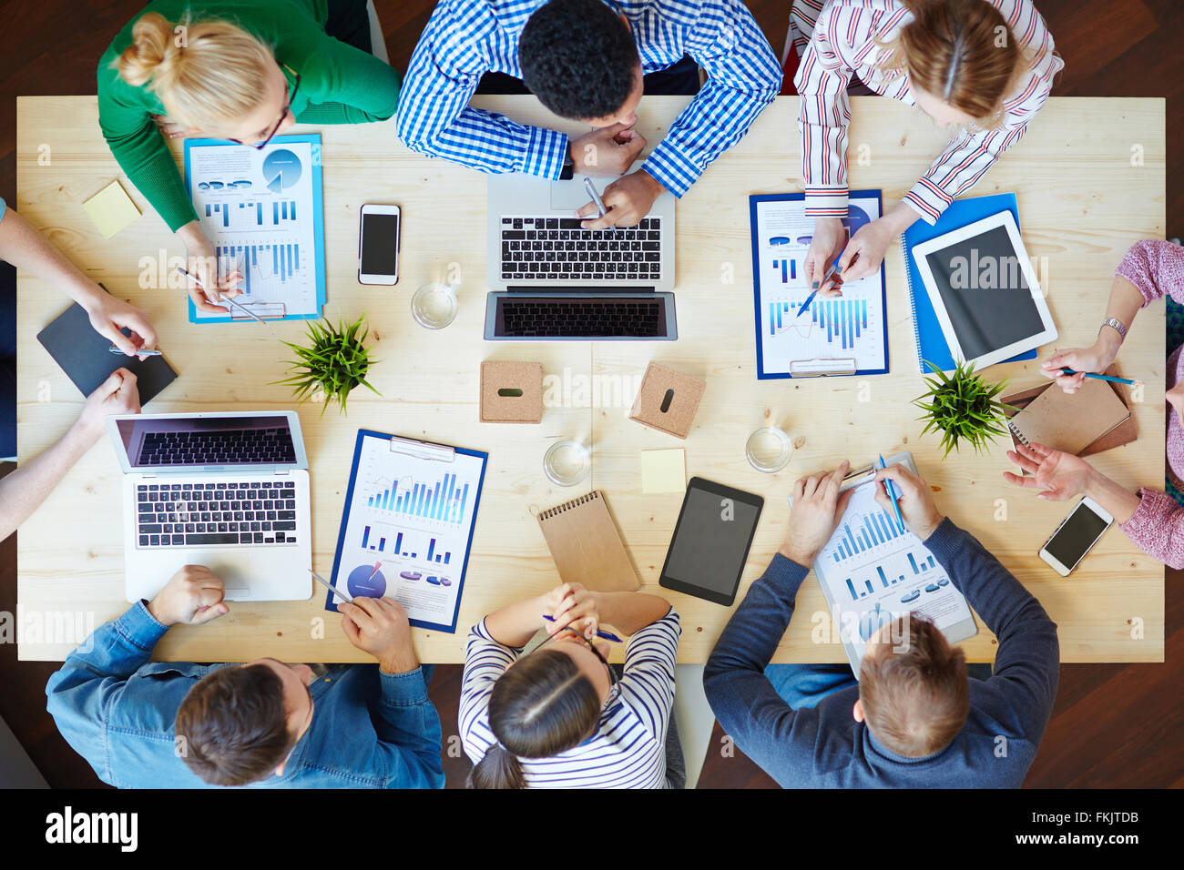 Above view of business team sitting around table and working Stock ...