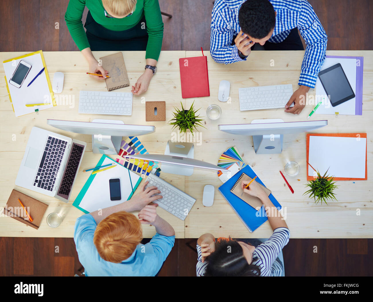Above view of group of young designers working together at the table ...