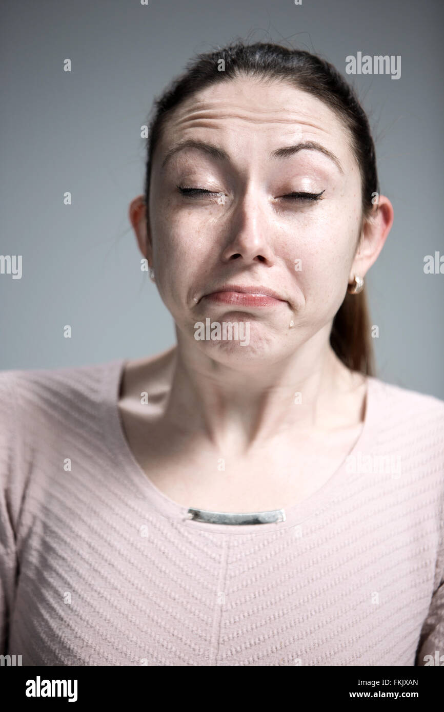 The crying woman with tears on face closeup on gray background Stock ...