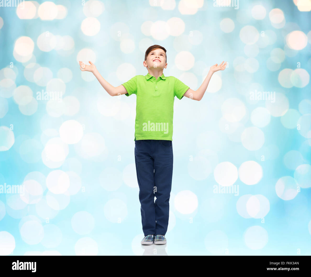happy boy in polo t-shirt raising hands up Stock Photo - Alamy