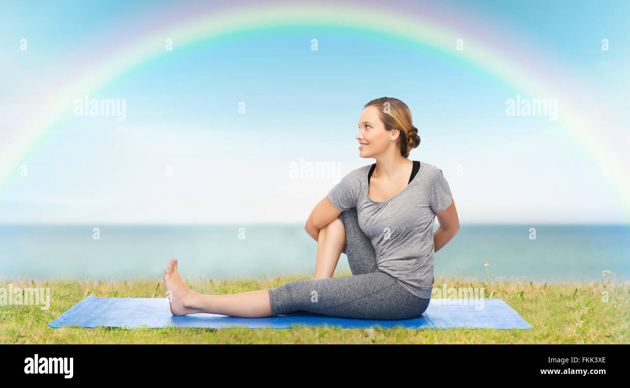 woman making yoga in twist pose on mat Stock Photo - Alamy