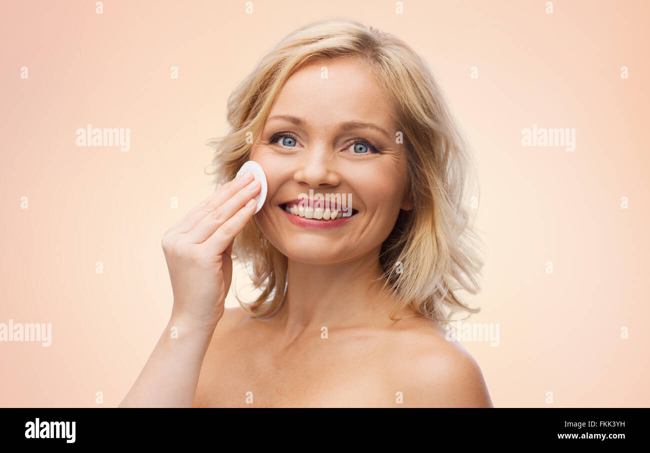 happy woman cleaning face with cotton pad Stock Photo - Alamy