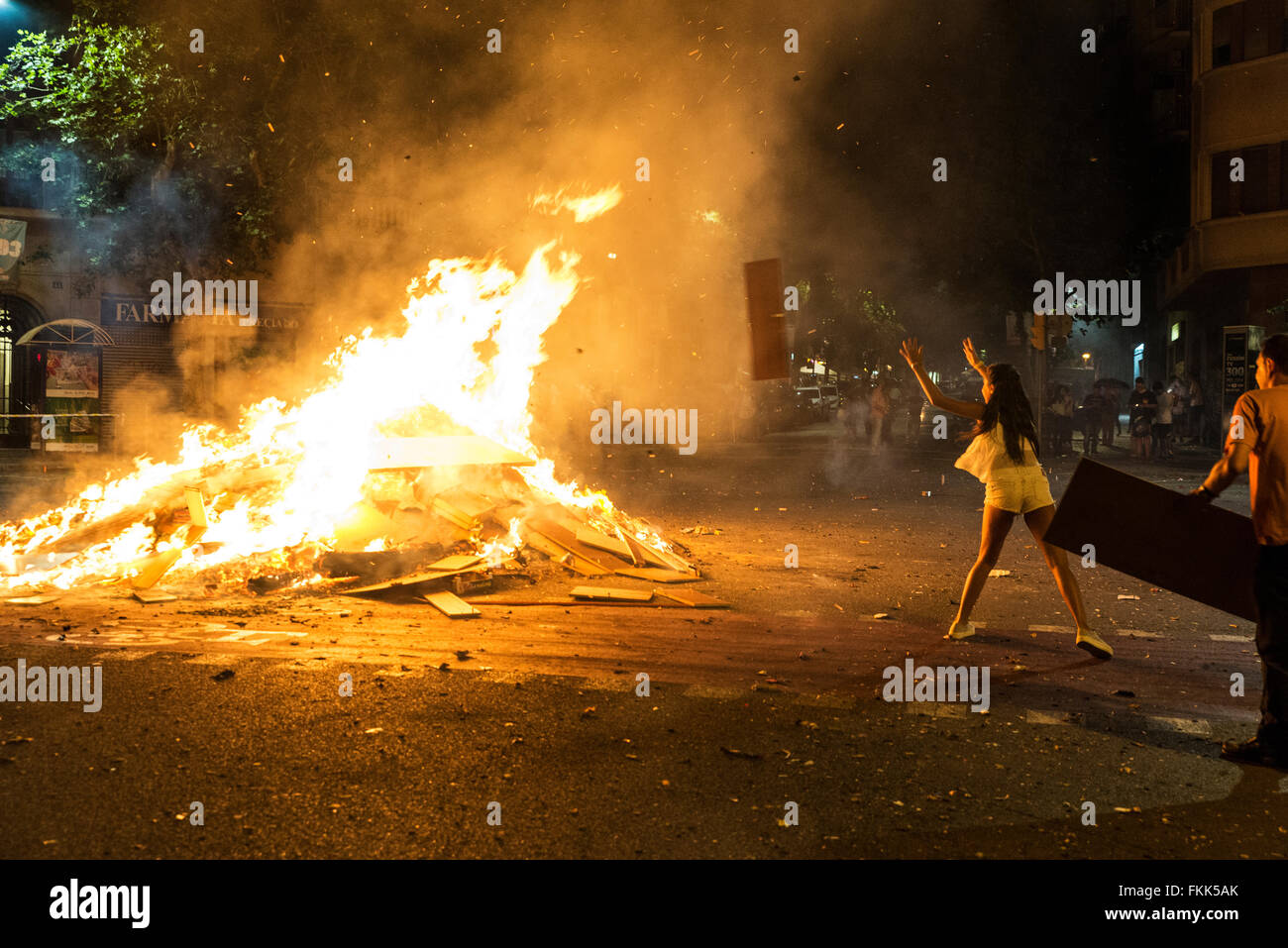 People throwing objects at a bonfire at night to celebrate the ...