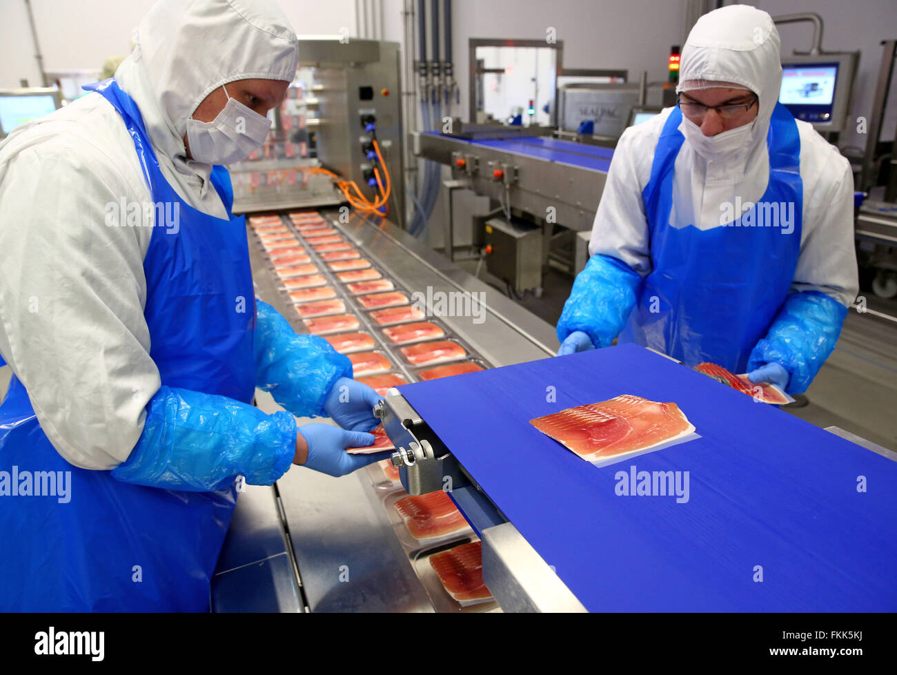 Bernburg, Germany. 9th Mar, 2016. Two employees preparing cut Serrano ...