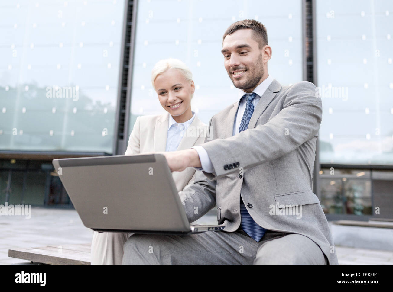 smiling businesspeople with laptop outdoors Stock Photo - Alamy