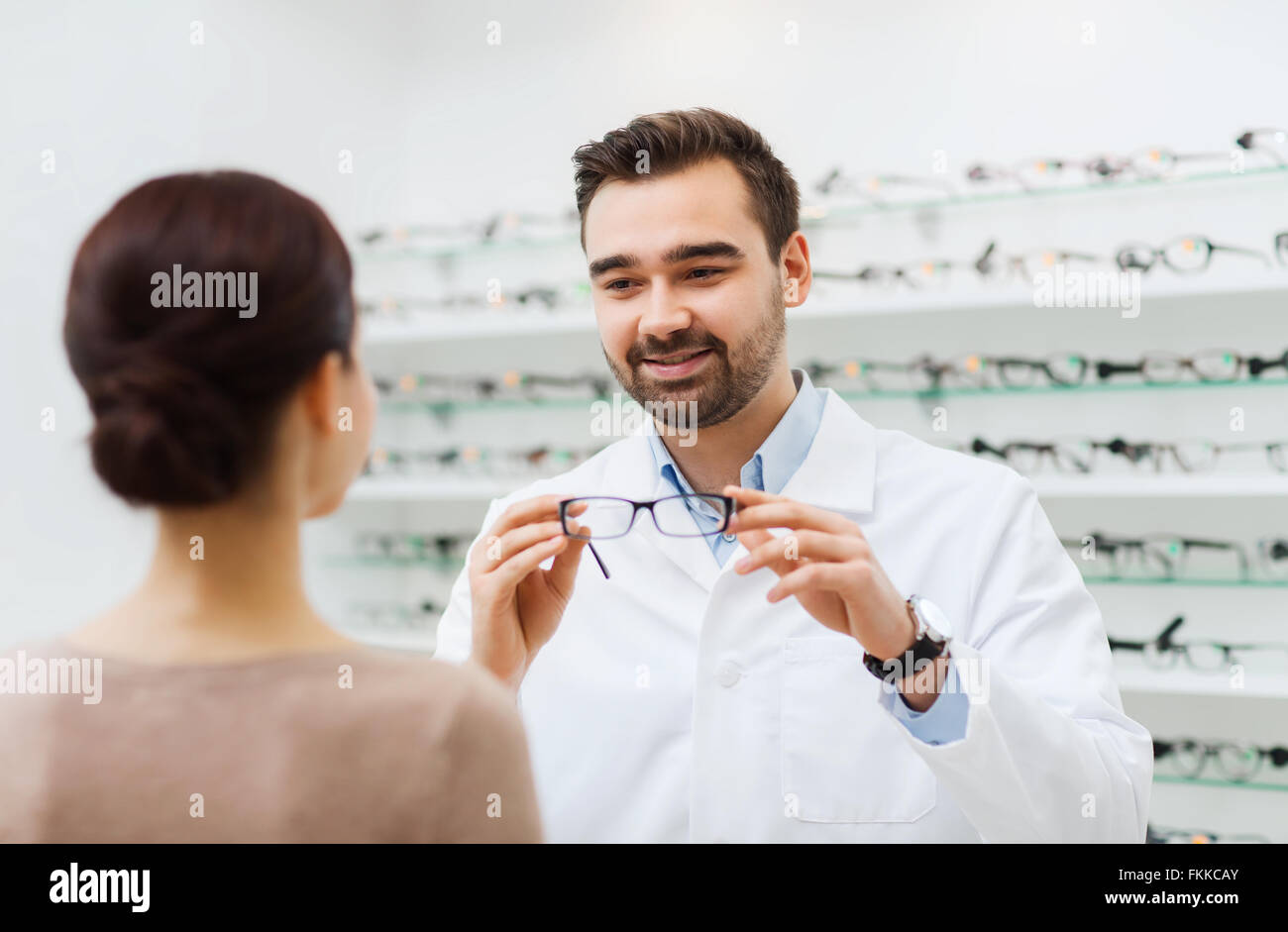woman and optician showing glasses at optics store Stock Photo - Alamy