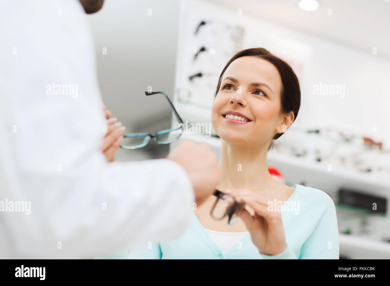 woman and optician showing glasses at optics store Stock Photo - Alamy