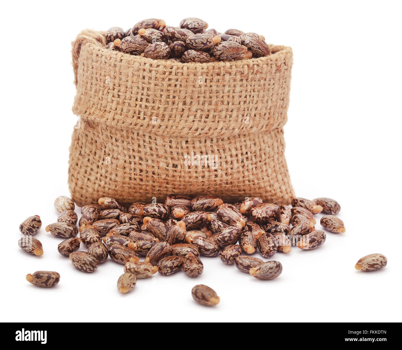 Castor beans in jute sack over white background Stock Photo - Alamy