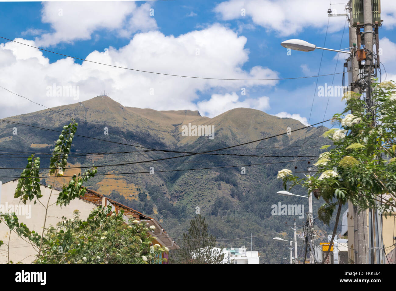 Day urban scene photo of houses and big mountains at background in a ...