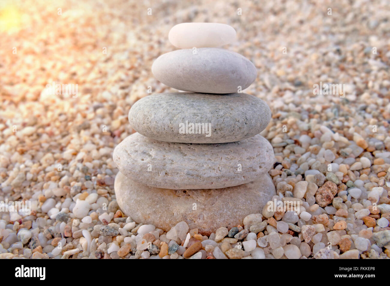 Stack of zen stones on beach with burning sun Stock Photo - Alamy