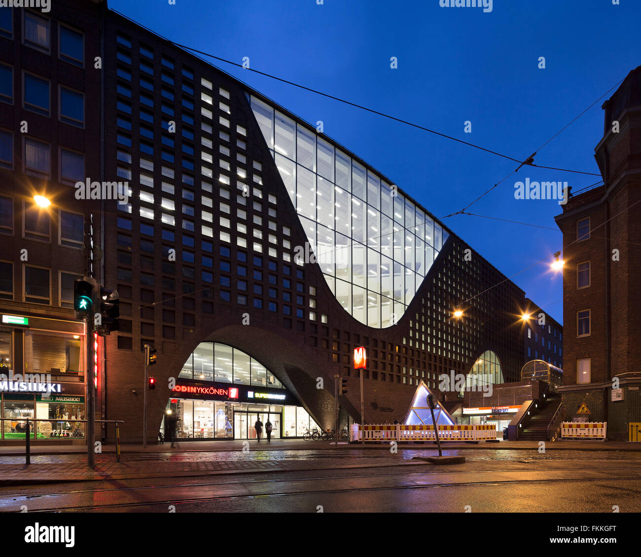 Exterior view of the central library at night time, traffic can be seen ...