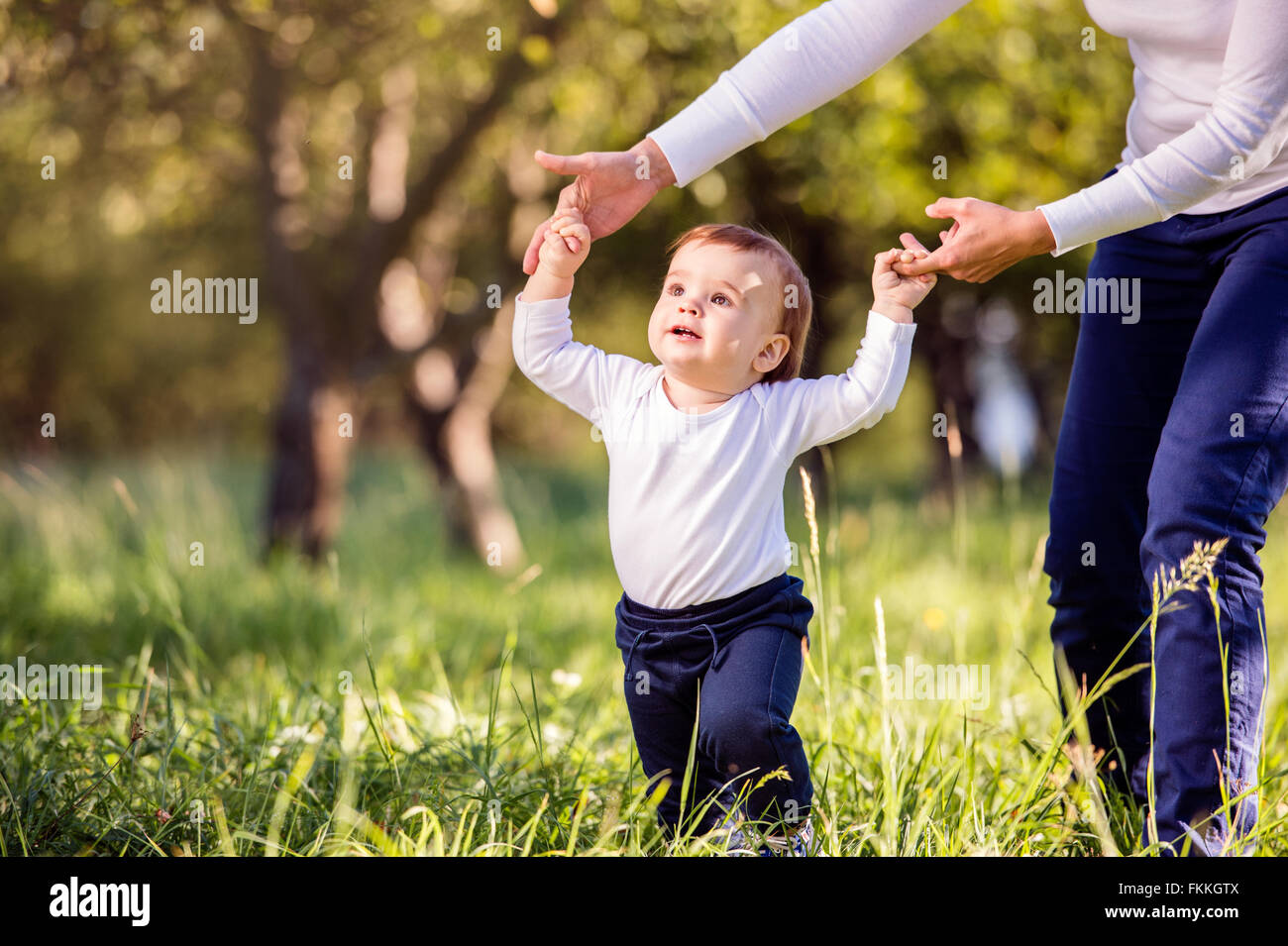 Mother holding hands of her son making first steps Stock Photo - Alamy