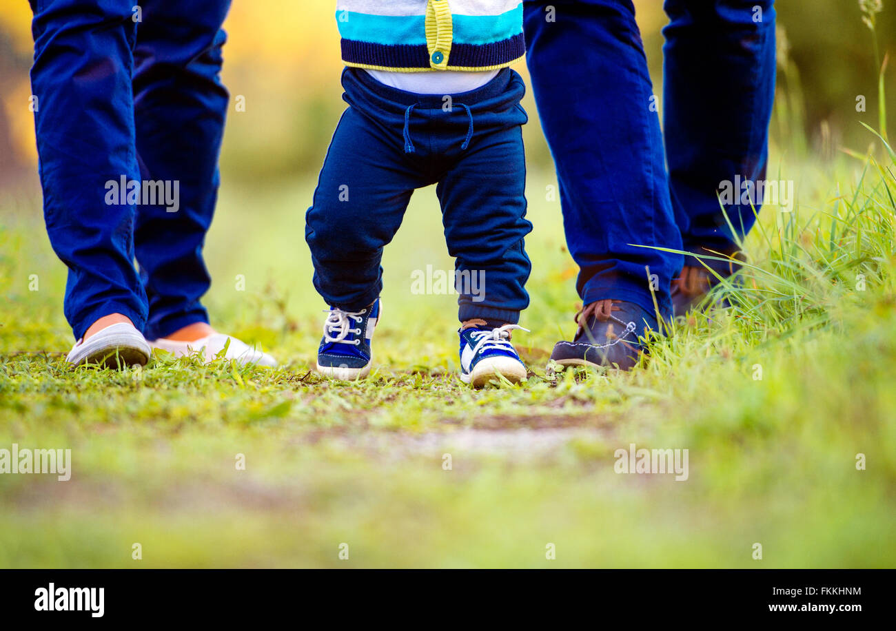Legs of mother, father, their son making first steps Stock Photo - Alamy