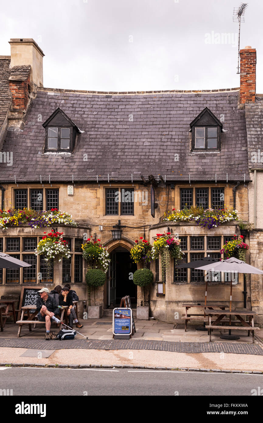 Tourists sitting outside a pub at Burford , Oxfordshire , England ...